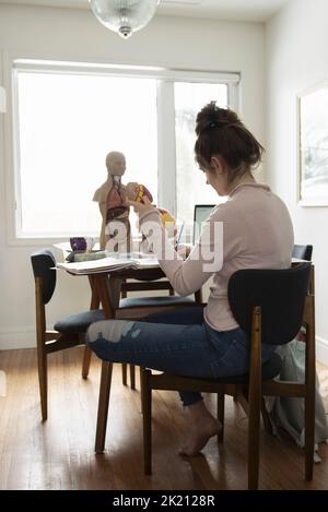 Teenage girl doing anatomy homework at dining table Stock Photo - Alamy