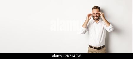 Businessman having headache, grimacing and holding hands on head ...