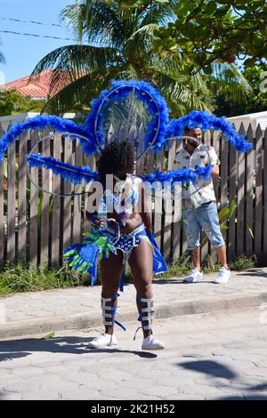 A young Belizean woman, in a blue costume, dancing and having fun in ...