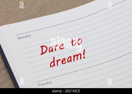 Dare to dream diary reminder message open on desk Stock Photo - Alamy