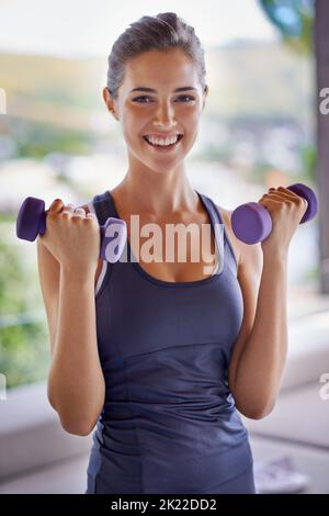 Getting the body shes always wanted. an attractive young woman flexing ...