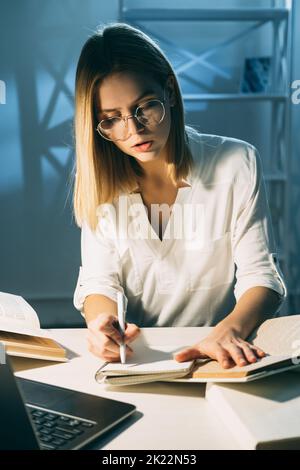 Student preparing for exams late at night in library Stock Photo - Alamy