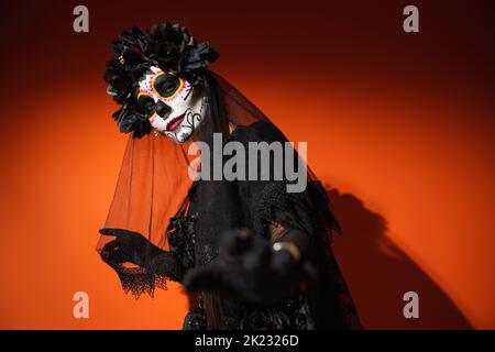 Woman in santa muerte costume and man in skeleton bodypainting for ...