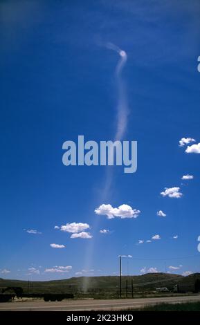 Dust Devil on a hot sunny day in a desert with red rocky mountains in ...