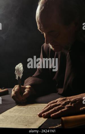 Medieval monk chronicler writing ancient manuscript under candlelight ...