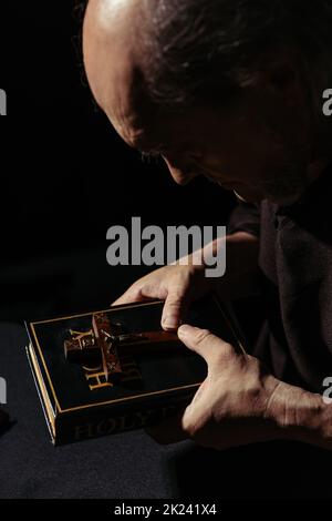 Medieval priest holding cross and holy bible performing exorcism rite ...