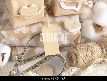 Valentines kraft paper wrapped present with square gift tag, hearts and ...