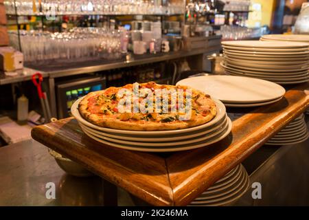 A freshly baked pizza is waiting to be picked up at the counter Stock ...