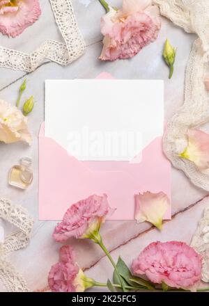 Envelope with blank card and flowers on grey background Stock Photo - Alamy