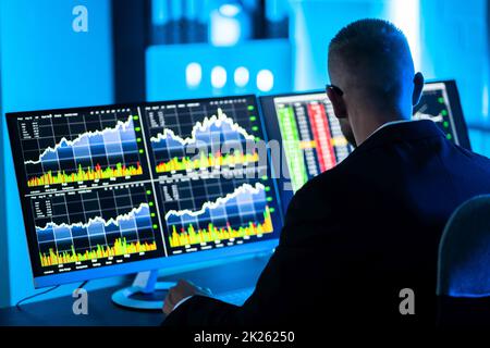 Stock Trader Man Using Multiple Computers Stock Photo - Alamy