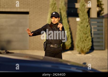 Police woman using walkie-talkie controlling road traffic Stock Photo ...