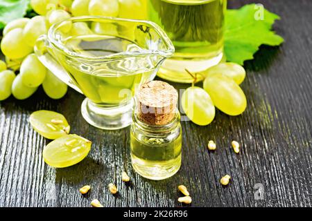 Oil grape in vial on light wooden board Stock Photo - Alamy