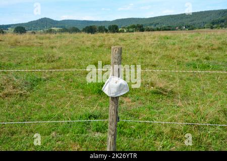Respirator mask hanging on a wooden pole in the green nature, with a ...