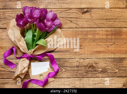 Purple tulips Bouquet and blank card on wooden table top view Stock ...