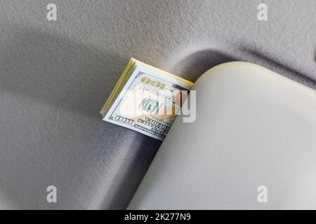 Money under the sun visor inside the car. Dollars in car Stock Photo ...