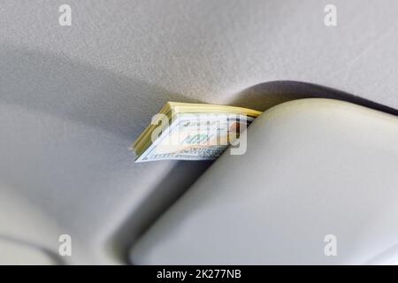 Money under the sun visor inside the car. Dollars in car Stock Photo ...