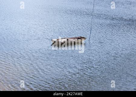 Little boat in the middle of the dam - the water in the sun shimmers ...