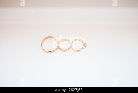 Three wedding rings on a shiny background Stock Photo - Alamy