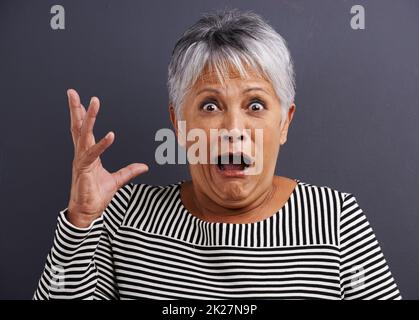 Scared mature woman on black background Stock Photo - Alamy