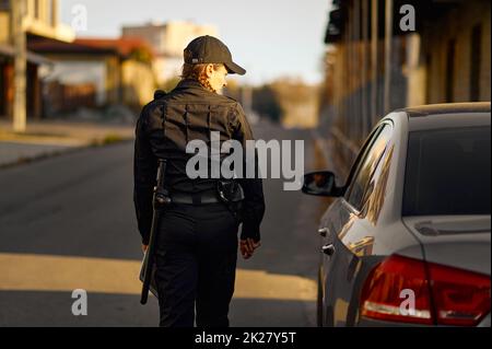 Female cop coming to car on road Stock Photo - Alamy