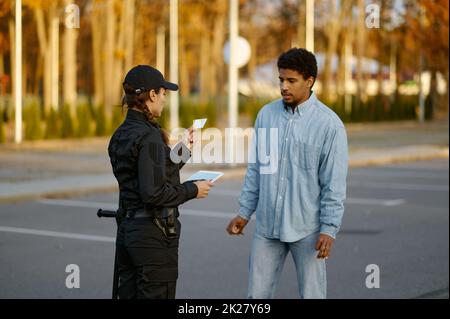Female cop checking male passerby ID document Stock Photo - Alamy