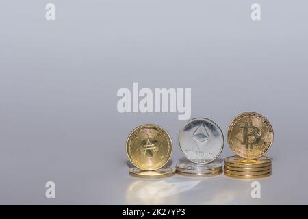 valueable crypto coins bitcoin ether and ada in a row with gray ...