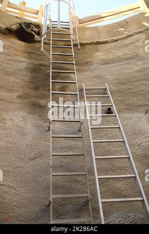 Ladder leading up from a pit Stock Photo - Alamy