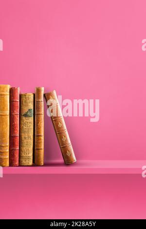 Row of old books on pink shelf. Horizontal background scene Stock Photo ...