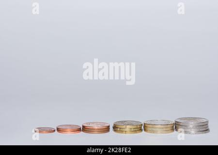 many euro coins stacked in a row increasing in value with gray ...