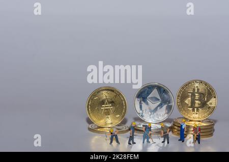 valueable crypto coins bitcoin ether and ada in a row with gray ...