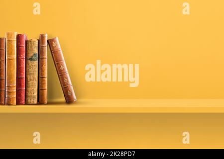Row of old books on yellow shelf. Square scene background Stock Photo ...