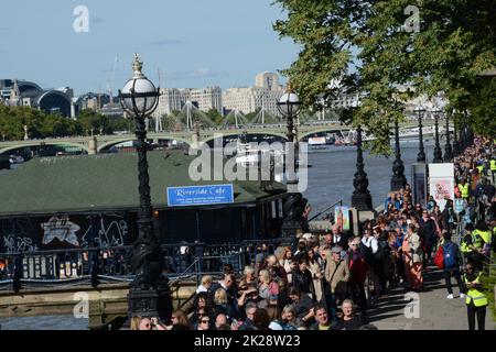 Mourners queue along the south bank of the Thames opposite the Houses ...