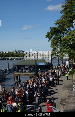 Mourners queue along the south bank of the Thames opposite the Houses ...