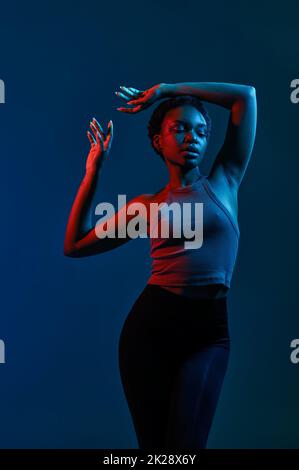 Woman moving gracefully over dark studio background Stock Photo - Alamy