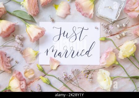 Card with the handwritten text JUST MARRIED surrounded by pink flowers ...