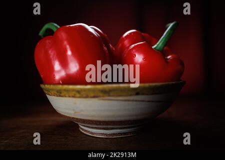 Two red pepper in bowl with red backround Stock Photo - Alamy
