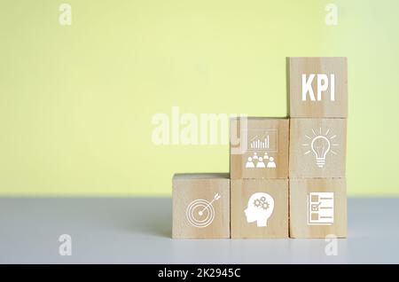 KPI, key performance indicator symbol. Businessman turns wooden cubes ...