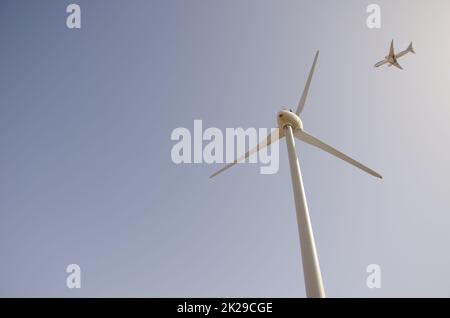 Airplane in flight and wind turbine Stock Photo - Alamy