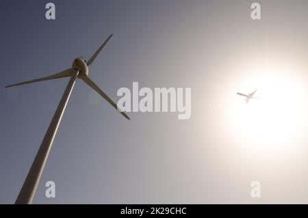 Airplane and wind turbine against the light Stock Photo - Alamy