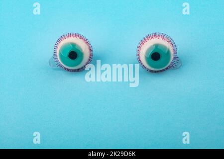 Decorative fruit candy eyes with red nose over light blue background ...
