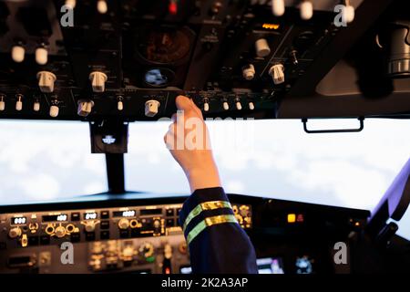 Female copilot pushing dashboard buttons to start engine and fly ...
