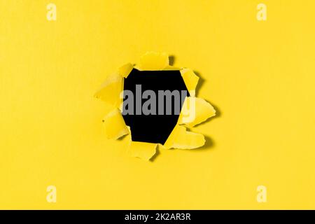 Hole with torn edges in yellow paper, full frame Stock Photo - Alamy