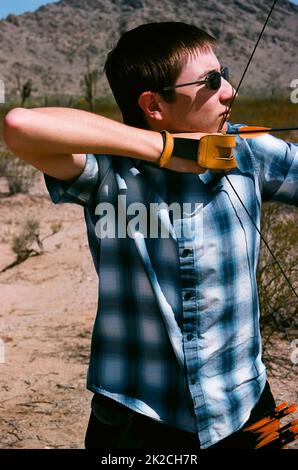 The Traditional Archer shooting a long bow in the desert Stock Photo ...