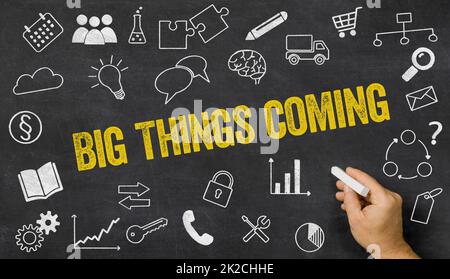 Big things coming written on a blackboard with icons Stock Photo - Alamy