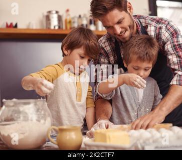 Baking with his brother. two young brothers baking in the kitchen Stock ...