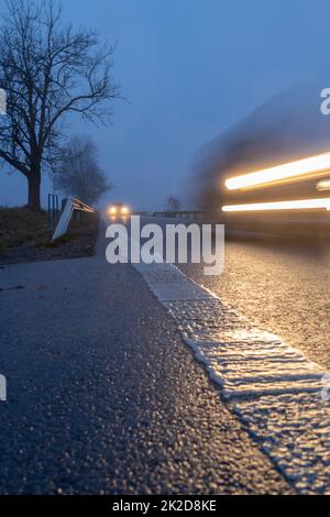 Lighted cars at dusk on main road Stock Photo - Alamy