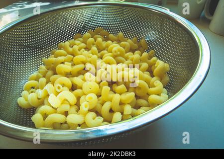Yellow spiral pasta in an aluminum colander Stock Photo - Alamy