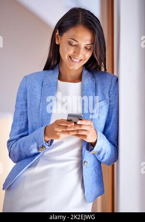 Sent with a smiley face. an attractive young woman sending a text ...