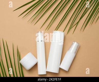 jar and empty white plastic tube for cosmetics on a pink background ...