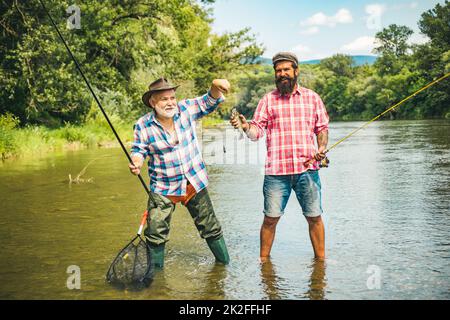 Two men friends fishing. Flyfishing angler makes cast, standing in ...